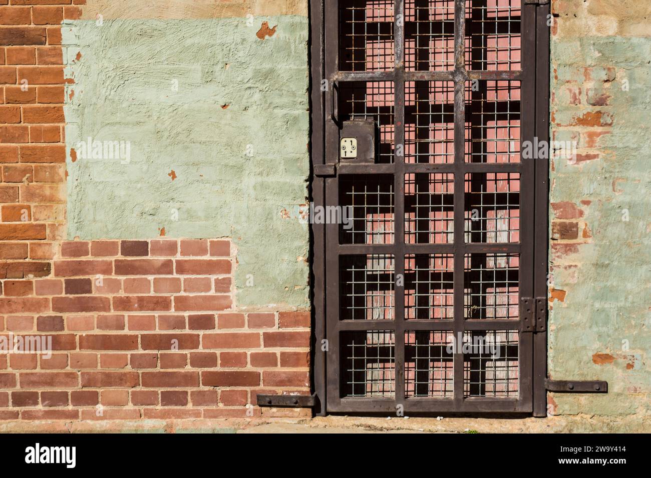 Old locked rusting metal jail style door Stock Photo - Alamy