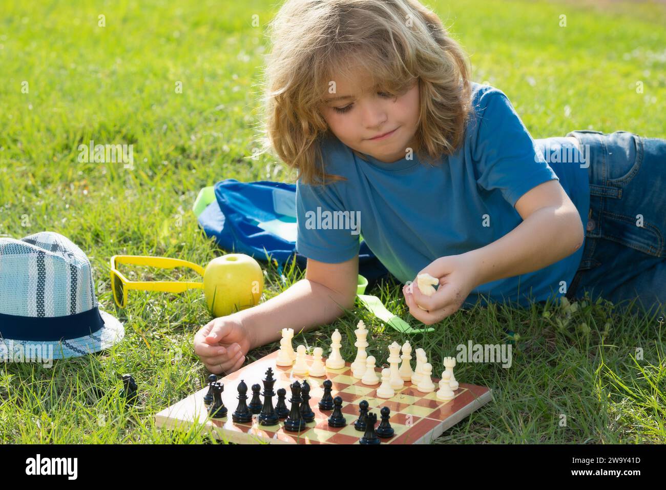 Clever concentrated and thinking kid boy playing chess. Logic game for ...