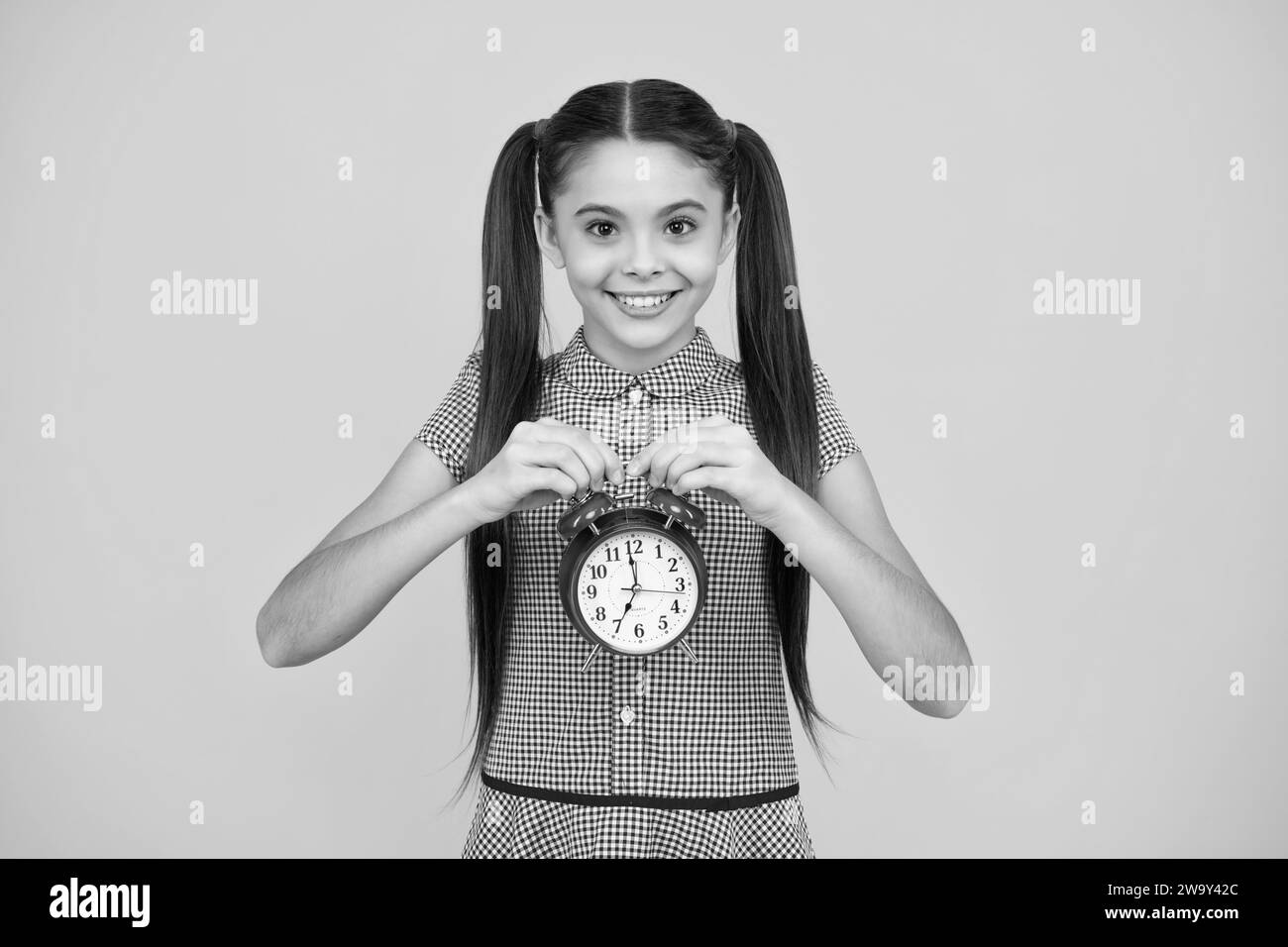 Portrait of teenage girl with clock alrm, time and deadline. Studio ...
