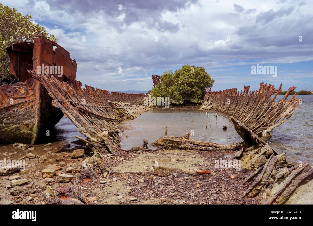 The corroding shell of a steel hulled ship wreck partially submerged at ...