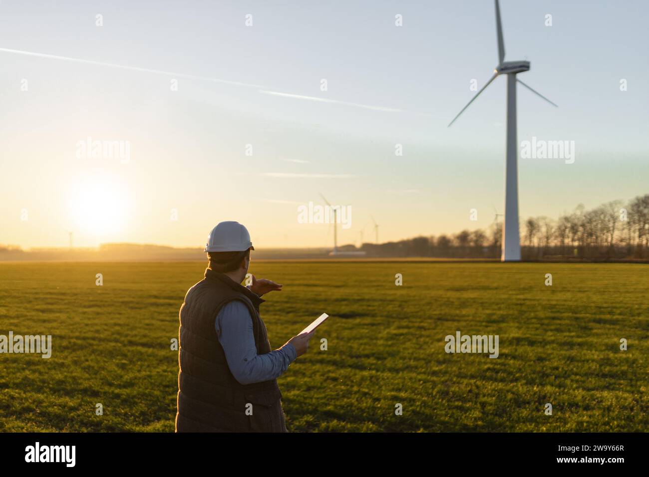 Businessman checking on wind turbine energy production Stock Photo - Alamy