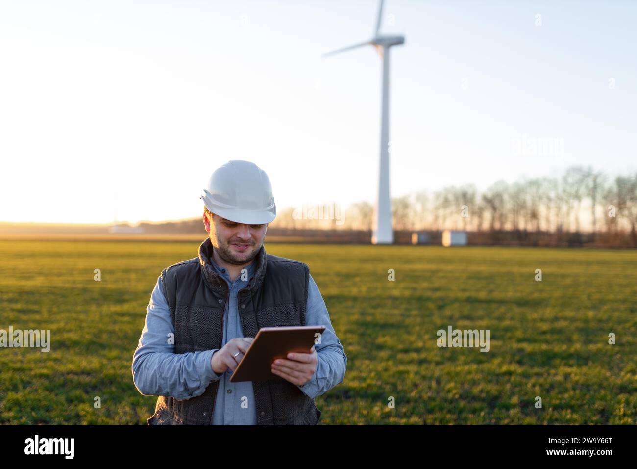 Businessman checking on wind turbine energy production Stock Photo - Alamy