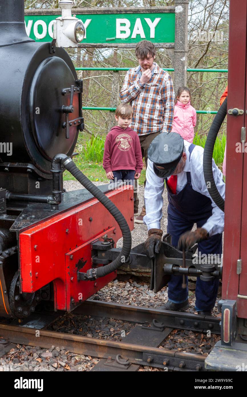 The driver coupling his steam locomotive to the train, watched by ...