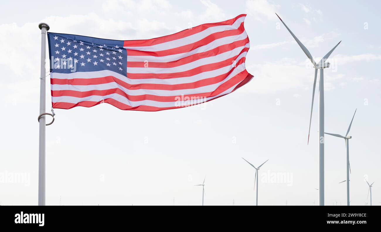 American flag flutters on the backgorund of wind turbines. Symbol of ...