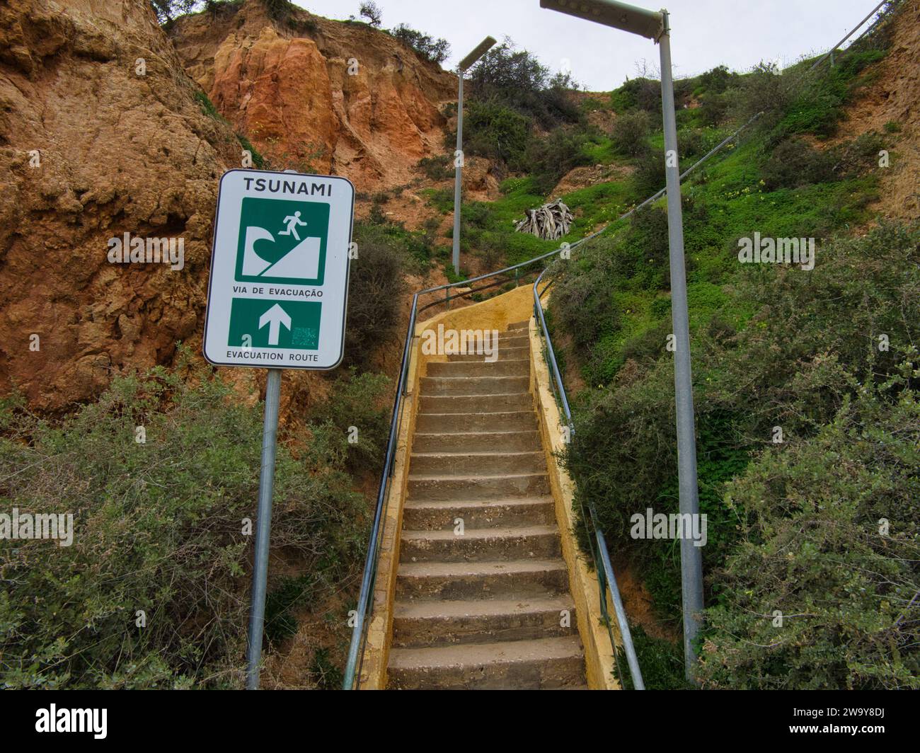 Tsunami sign next to a staircase leading to a beach with some street ...