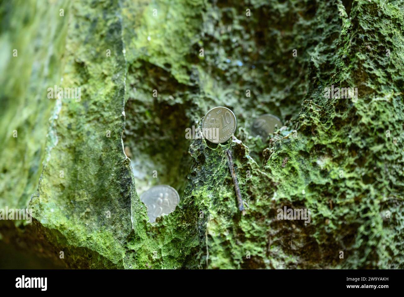Malaysian coins left on the rock face for luck at Geotapak, Ipoh, Perak ...