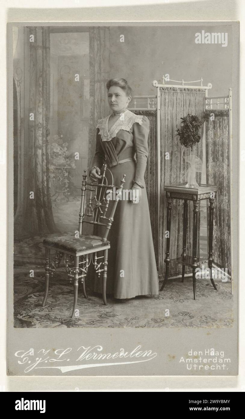Studio Portrait of a woman in a long dress at a folding screen, 1890 - 1915 photograph The Hague ...