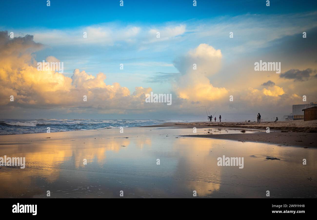 People fish at dusk on Bou Jaafar beach on the Mediterrenean Sea in ...