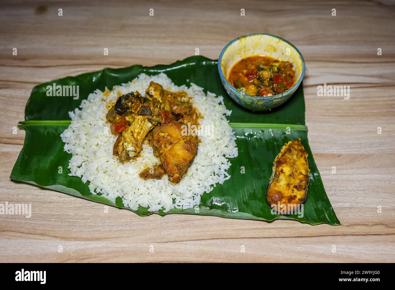 fresh and hot fish and rice cooked meal served at banana leaf for ...