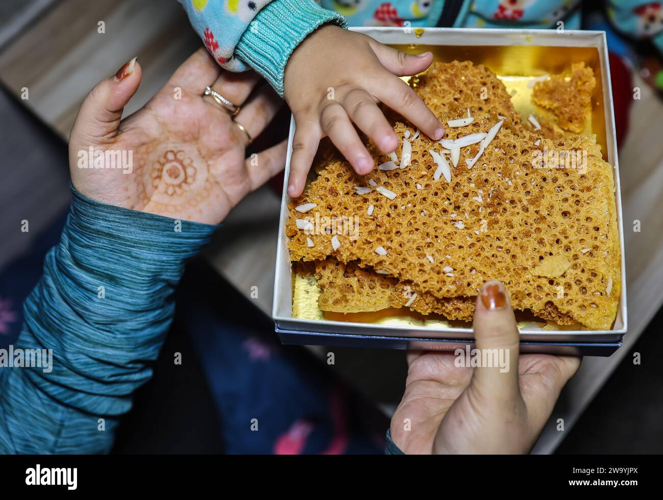people sharing ghewar traditional indian delicious sweet close up shot ...