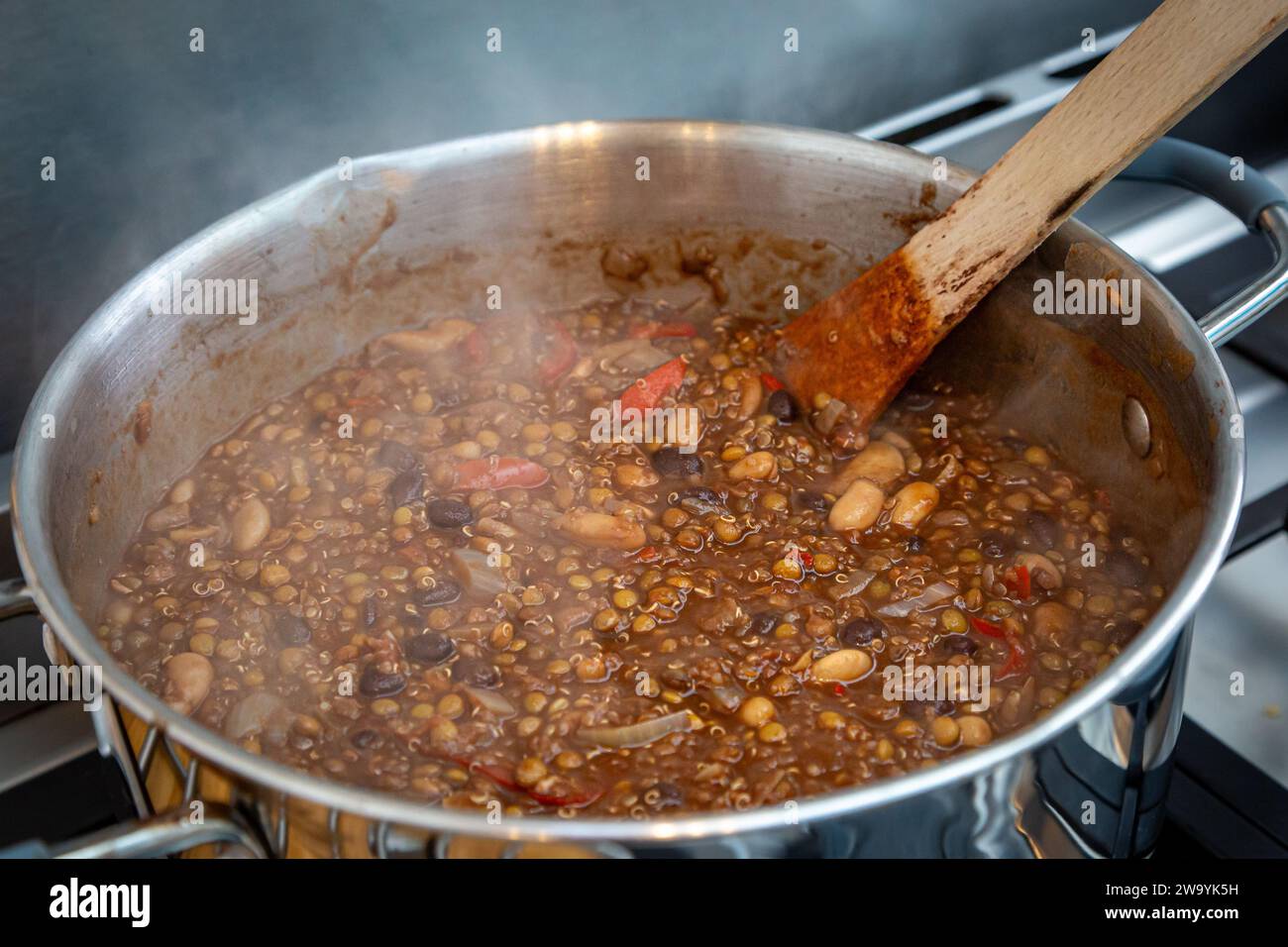 A saucepan of steaming chilli cooking on a hob Stock Photo - Alamy
