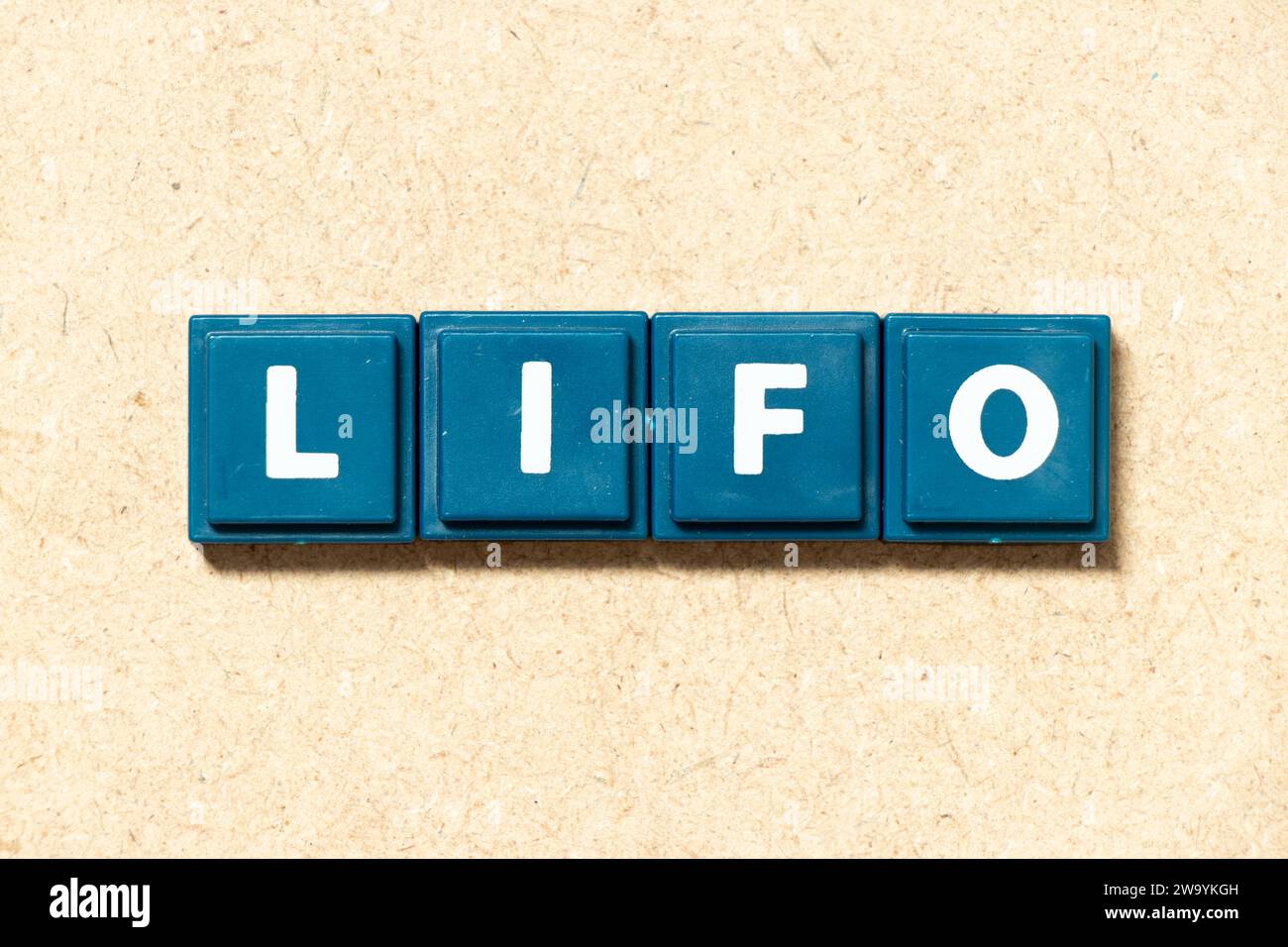 Tile alphabet letter in word LIFO (abbreviation of last in first out) on wood background Stock ...