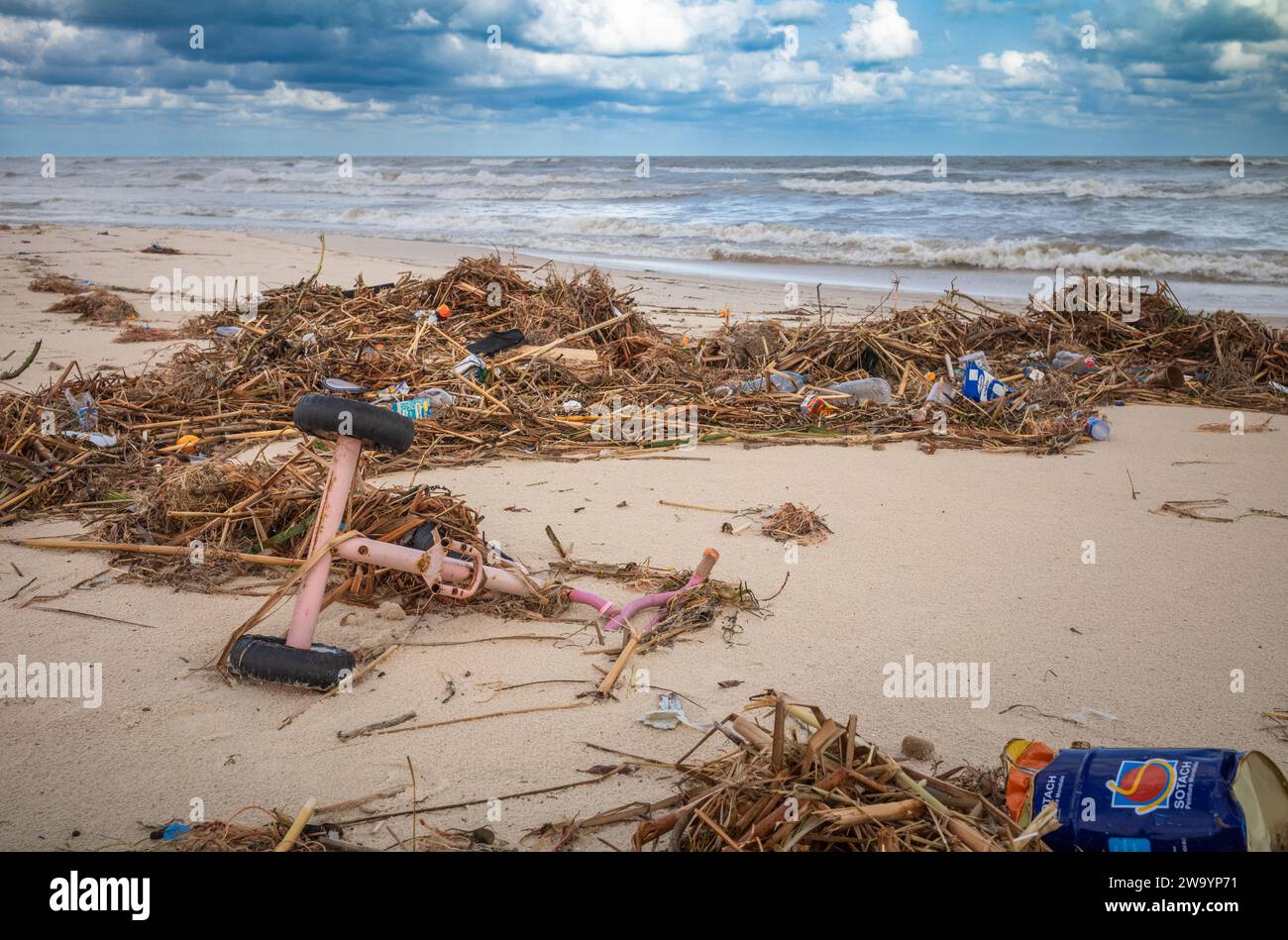 Vegetation mixed with metal and plastic waste and a washed up child's ...