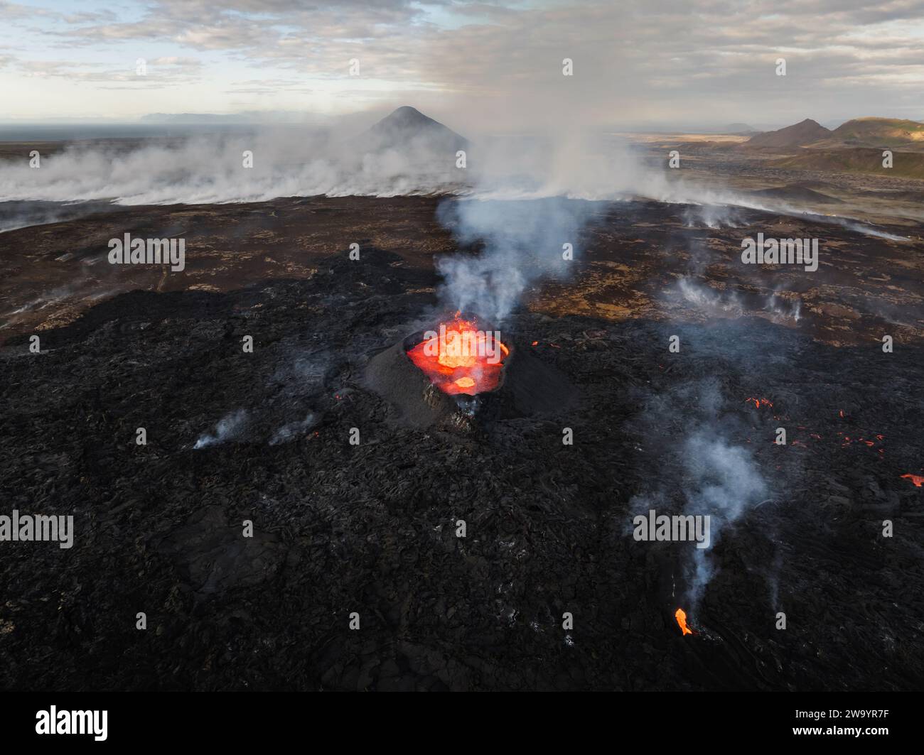 Flowing lava, hot magma spilling out of the volcano crater, aerial side ...