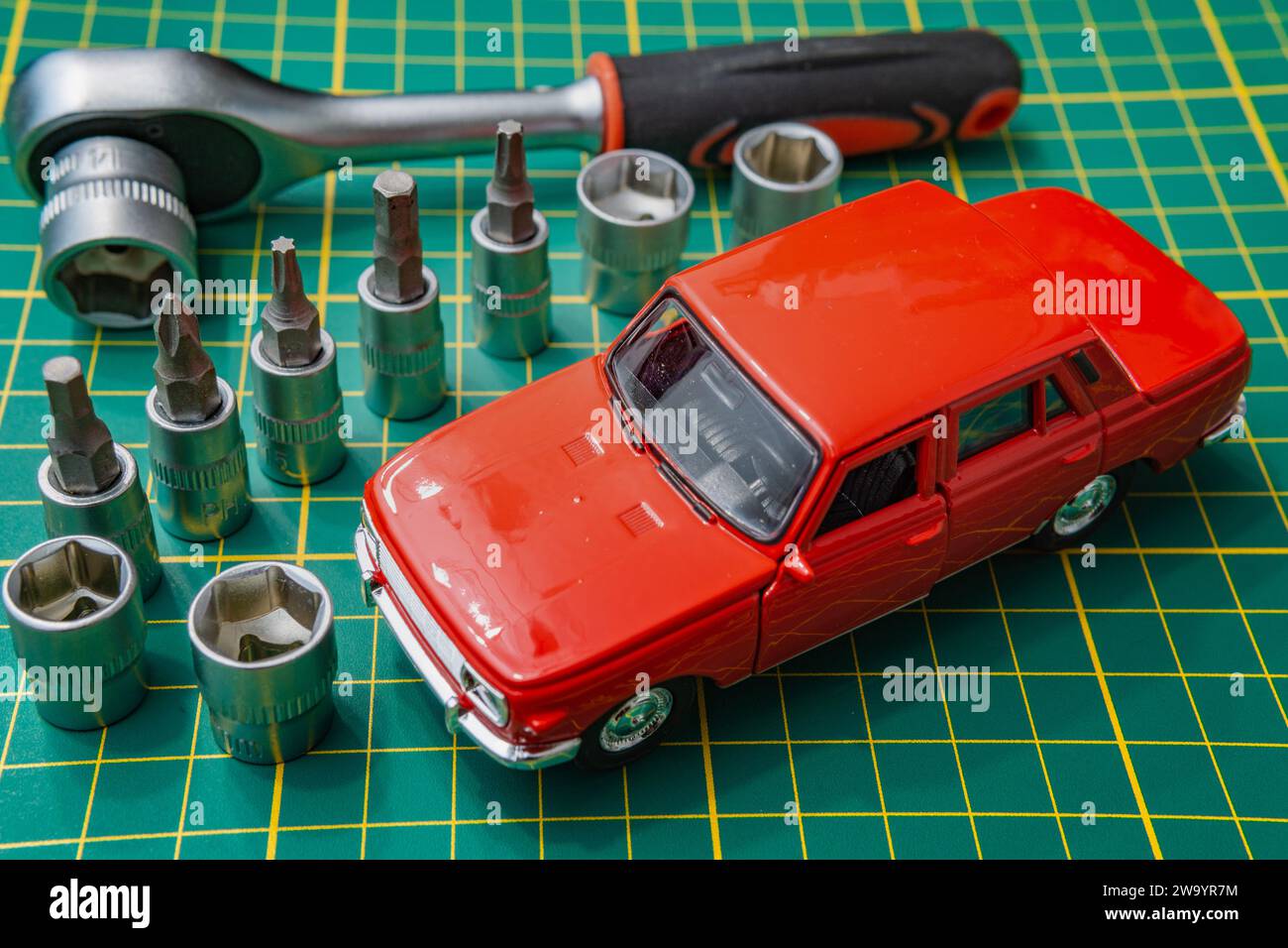 Toy car on grid pattern with screwdriver and bits self repair used car ...