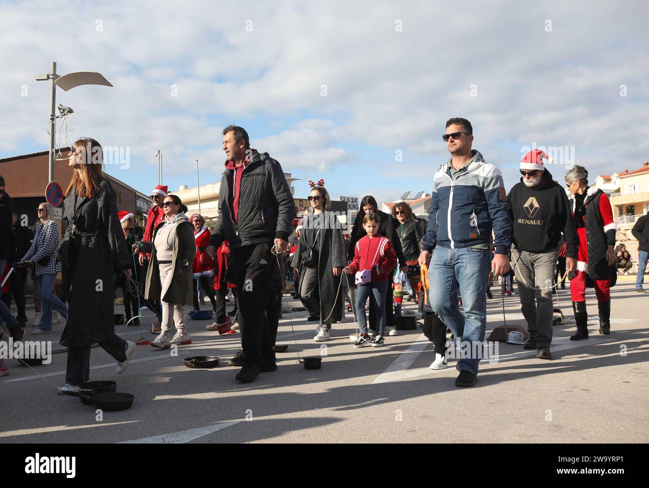 Primosten, Croatia. 31st Dec, 2023. People walk and drag their pots ...