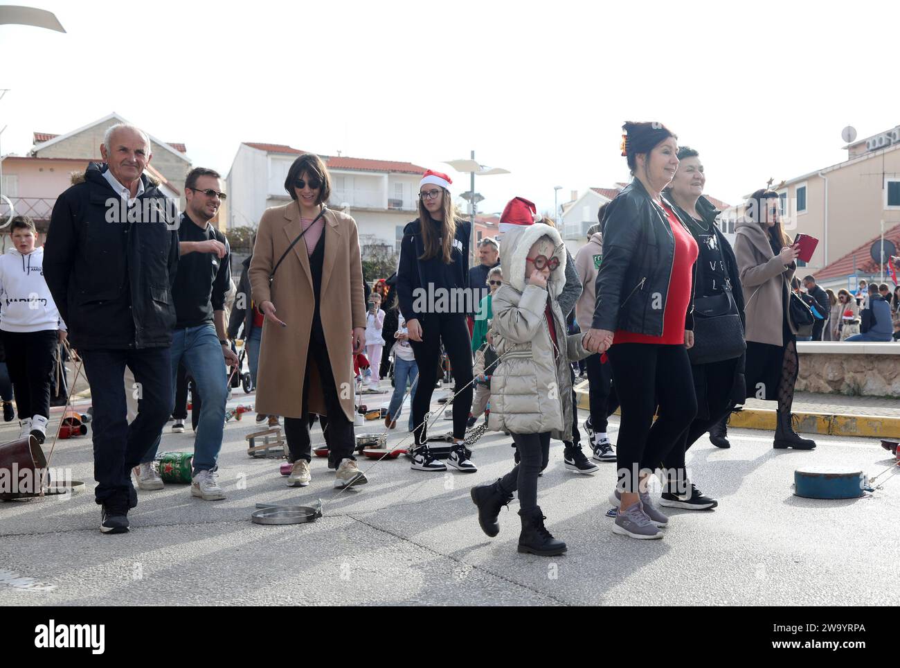Primosten, Croatia. 31st Dec, 2023. People walk and drag their pots ...