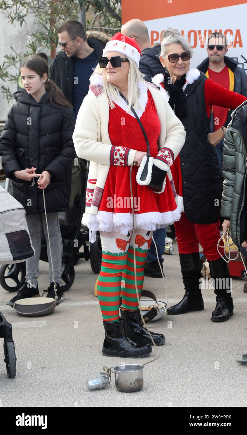 Primosten, Croatia. 31st Dec, 2023. People walk and drag their pots ...