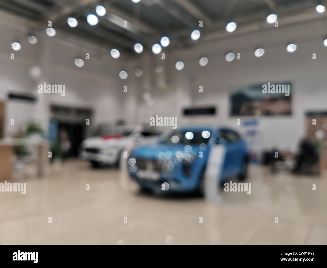 Blurred new car parked in modern showroom waiting for sales. Abstract ...