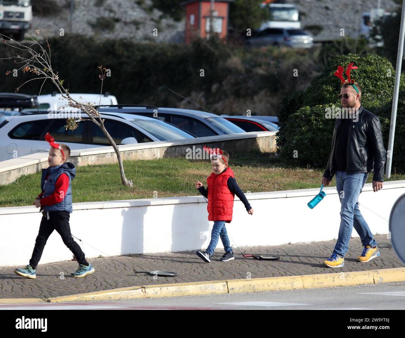 Primosten, Croatia. 31st Dec, 2023. People walk and drag their pots ...