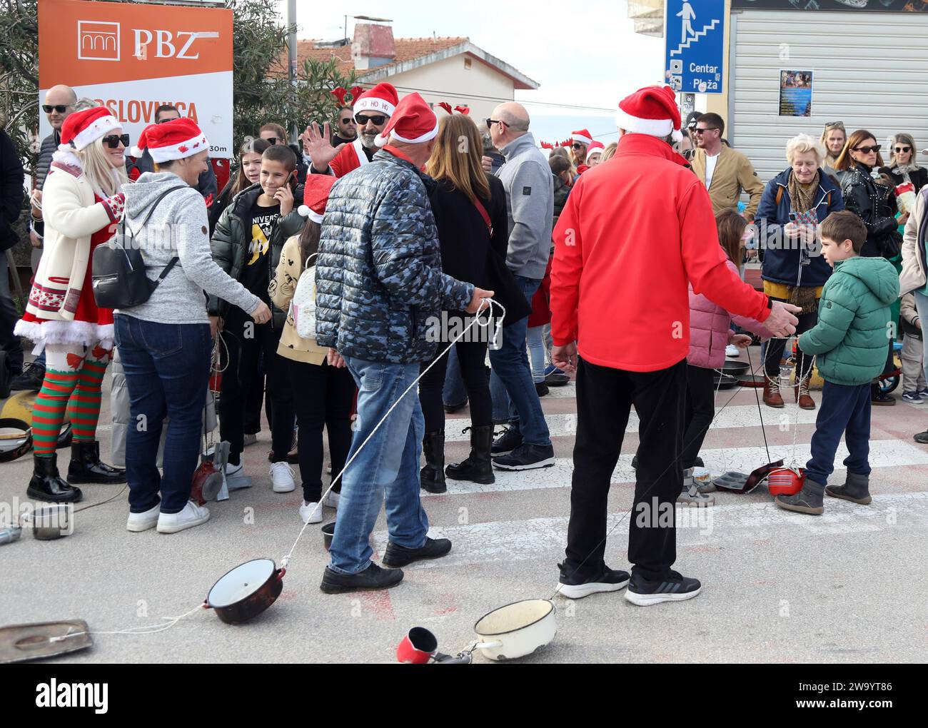 Primosten, Croatia. 31st Dec, 2023. People walk and drag their pots ...