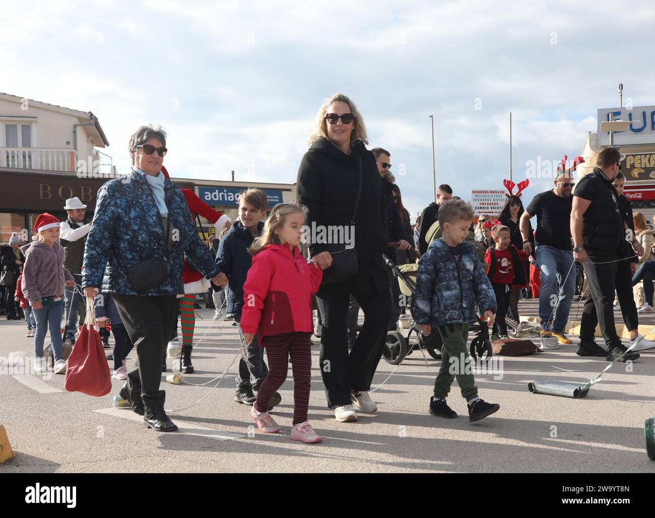 Primosten, Croatia. 31st Dec, 2023. People walk and drag their pots ...
