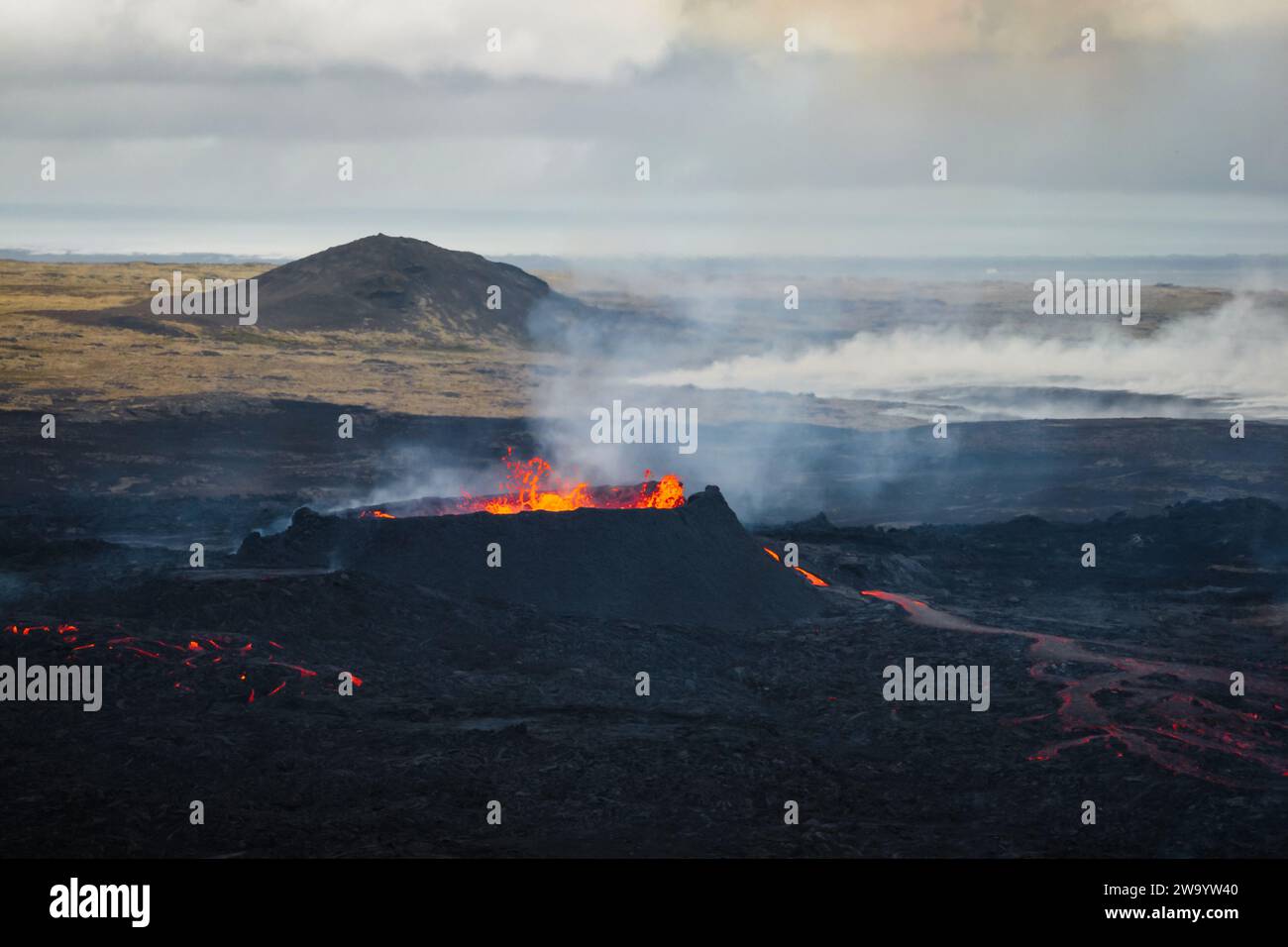 Dramatic view of an erupted volcano, red magma boiling in a crater ...