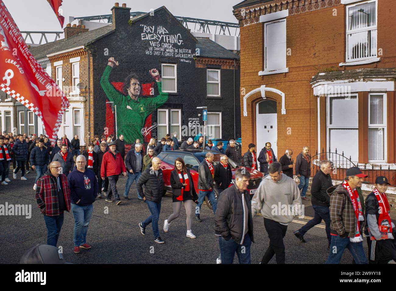 Liverpool FC supporters walk past a mural in Anfield with the stadium ...