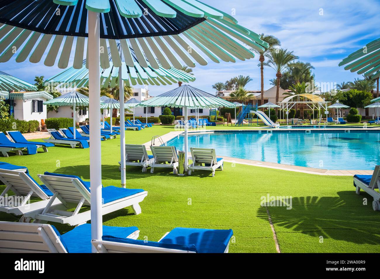 Beautiful swimming pool in tropical resort with palms. Swimming pool ...
