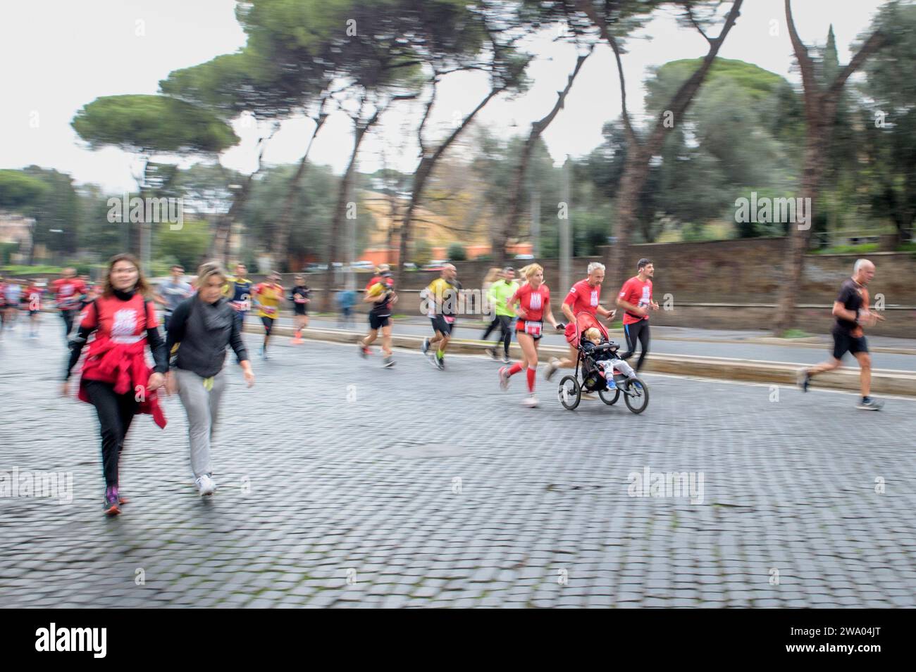 Rome, Italy. 31st Dec, 2023. A woman and a man runners push the pram ...