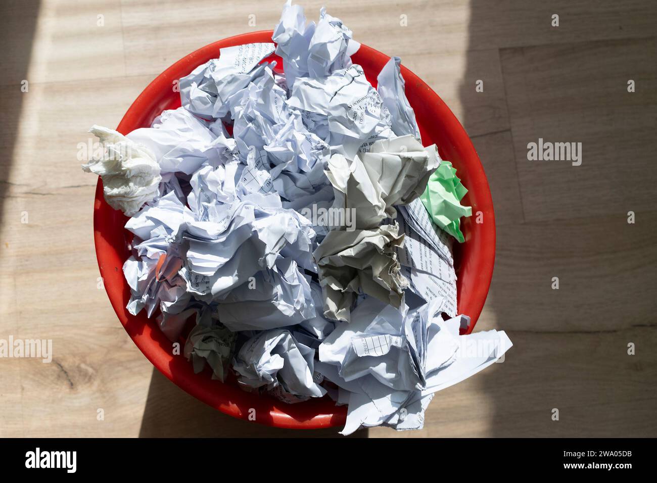 Full trash bin with crumpled paper scattered around Stock Photo - Alamy