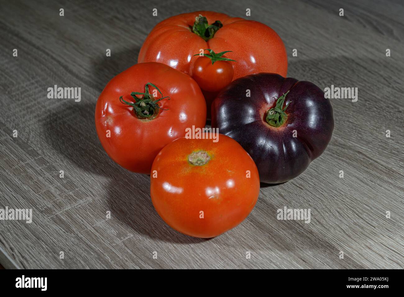 A group of four types of freshly harvested raw tomatoes, two types of ...