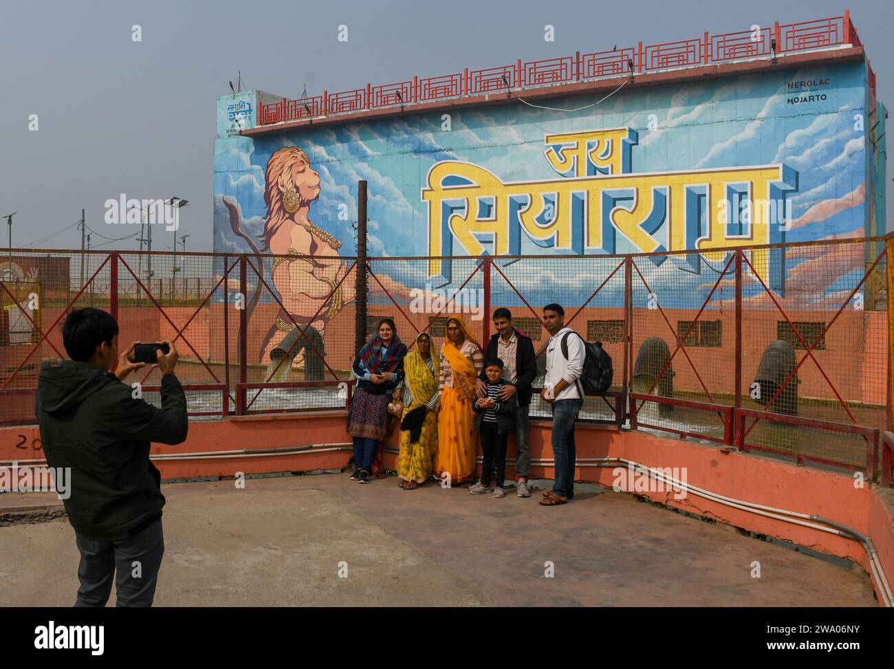 People take photos in front of a mural of the Hindu god Hanuman in ...