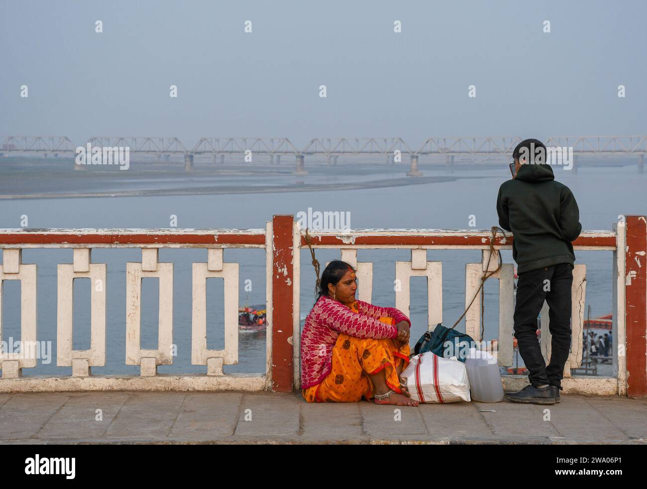 A woman sits on a bridge over the Sarayu River in Ayodhya. Ayodhya is ...