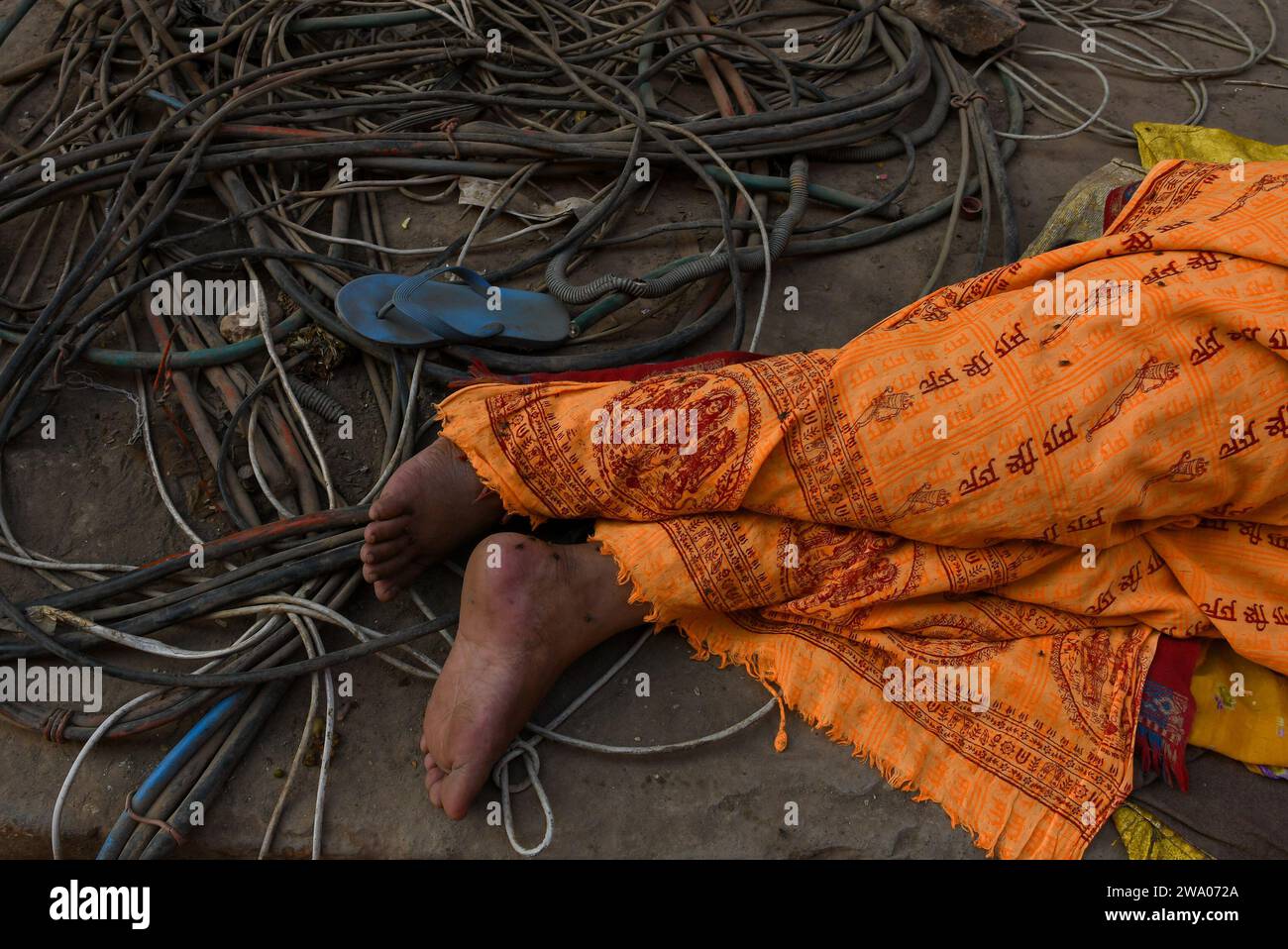 Ayodhya, India. 26th Dec, 2023. A man sleeps on the pavement in front ...