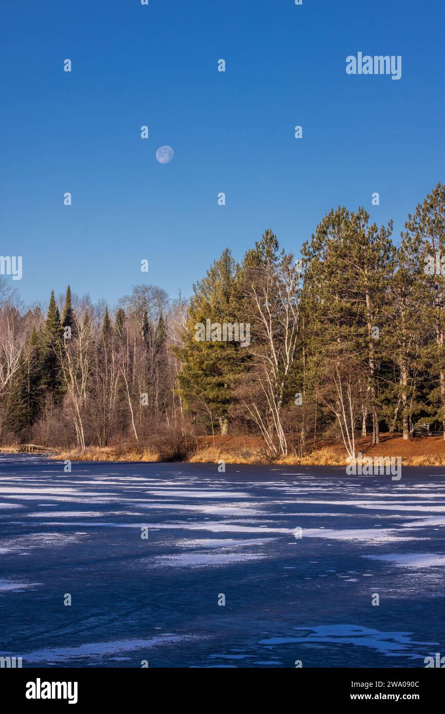 The moon setting over Loretta Lake in northern Wisconsin Stock Photo ...