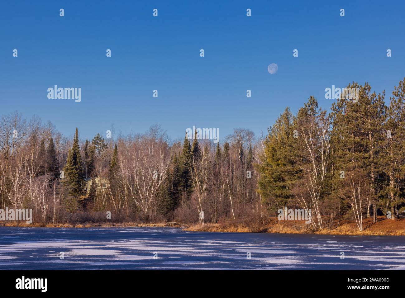 The moon setting over Loretta Lake in northern Wisconsin Stock Photo ...