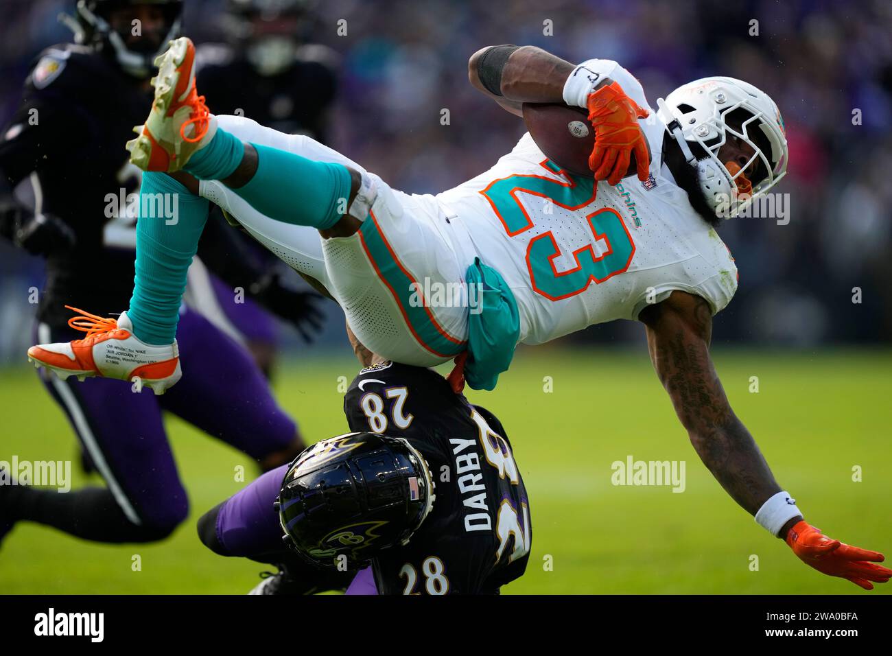 Miami Dolphins running back Jeff Wilson Jr. (23) is upended by Baltimore Ravens cornerback ...