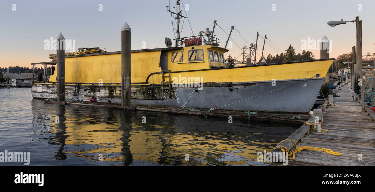 Open gate on Port of Peninsula Dock houses an old wooden fishing boat ...