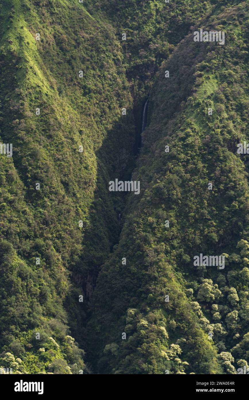 A secluded waterfall nestled in the crevices of West Maui Mountains, as ...