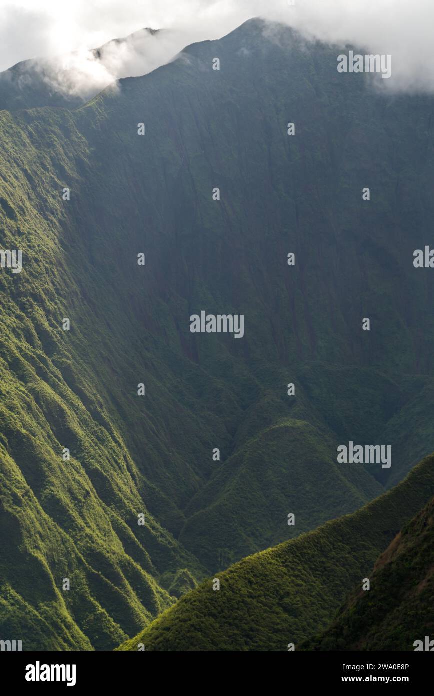 Light cascades down the lush mountain valley of Waihe'e Ridge in Maui ...