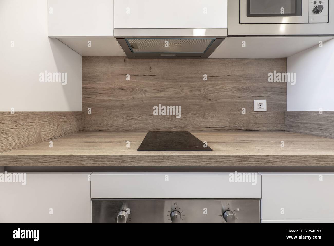 Front image of a kitchen with white cabinets and oak countertops with ...
