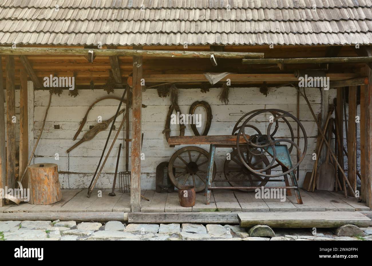 Collection of planers and retro wood saws hang on a wooden wall near an ...