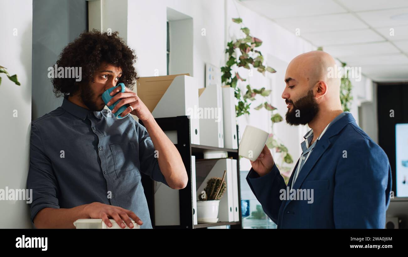 Coworkers joking around on coffee break, having conversation and ...