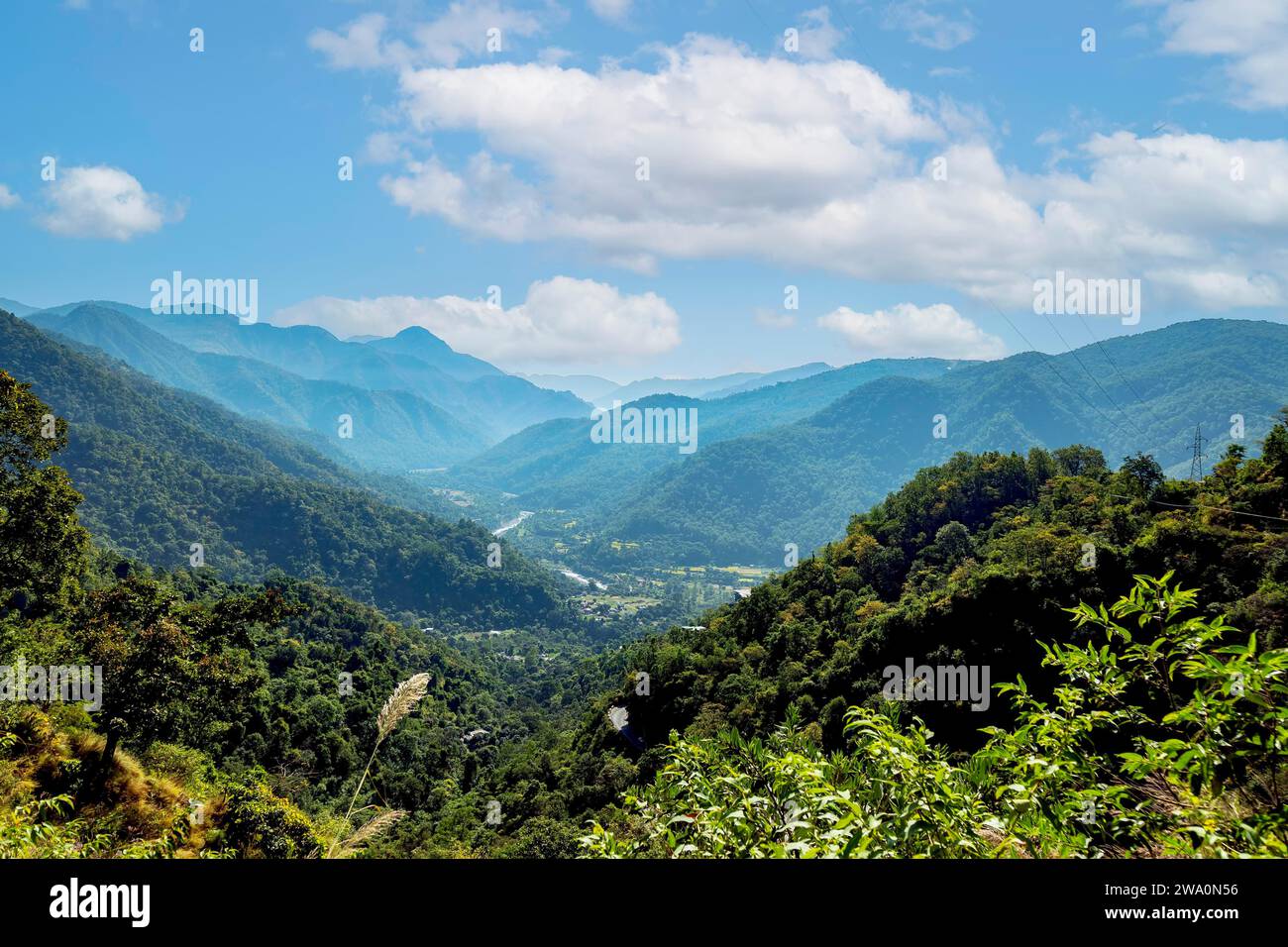 Scenic view of a green valley surrounded by lush mountains under a ...