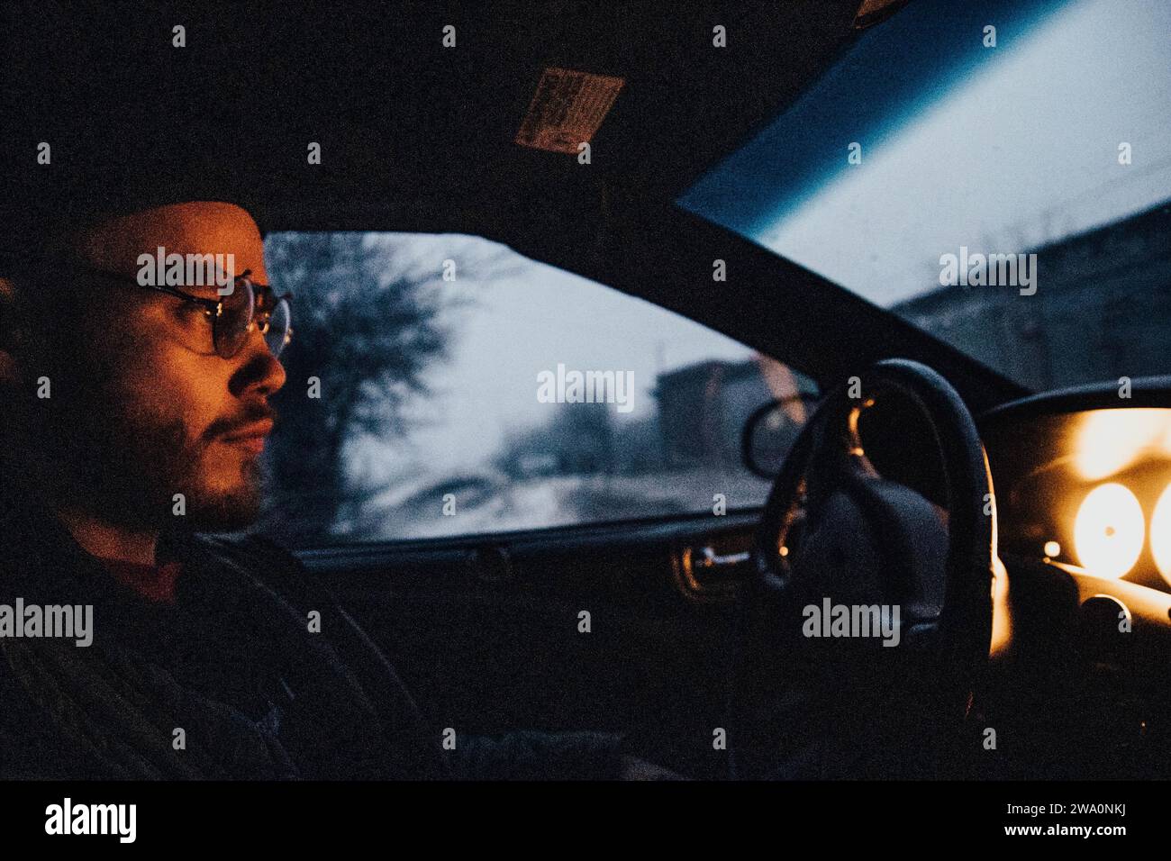 Handsome stylish bearded man driver sitting behind the wheel of a car ...