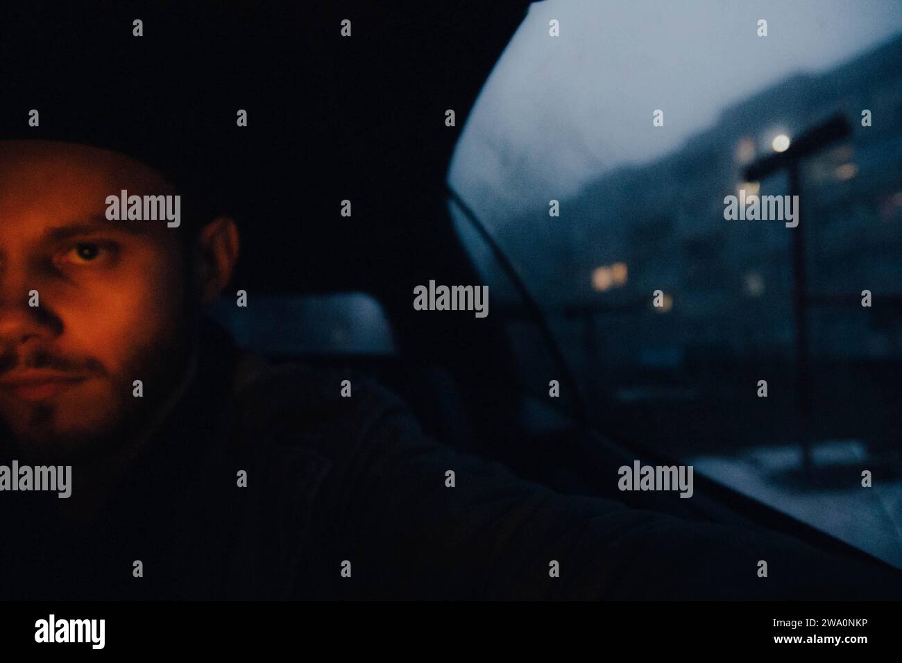 Handsome stylish bearded man driver sitting behind the wheel of a car ...
