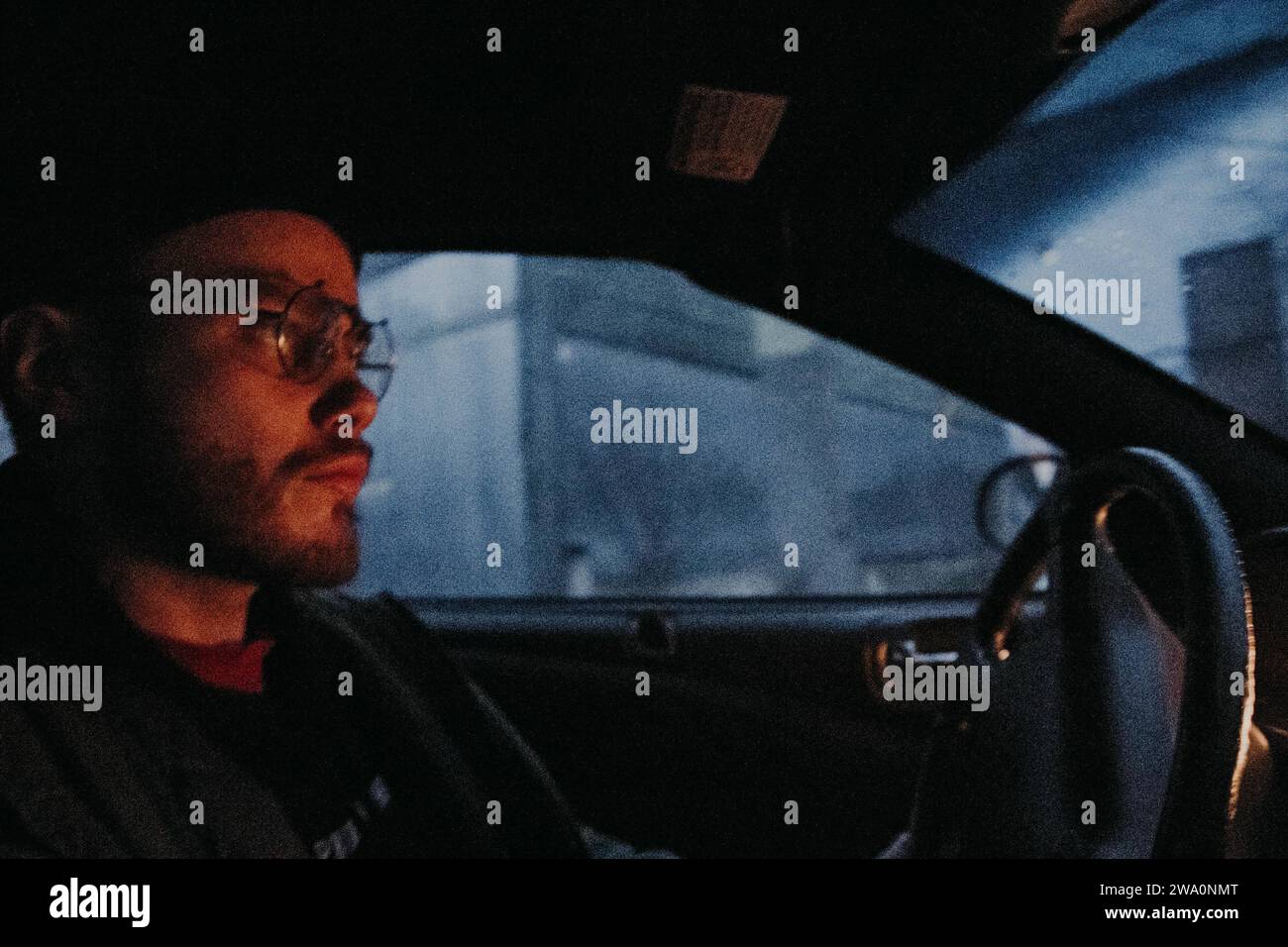 Handsome stylish bearded man driver sitting behind the wheel of a car ...