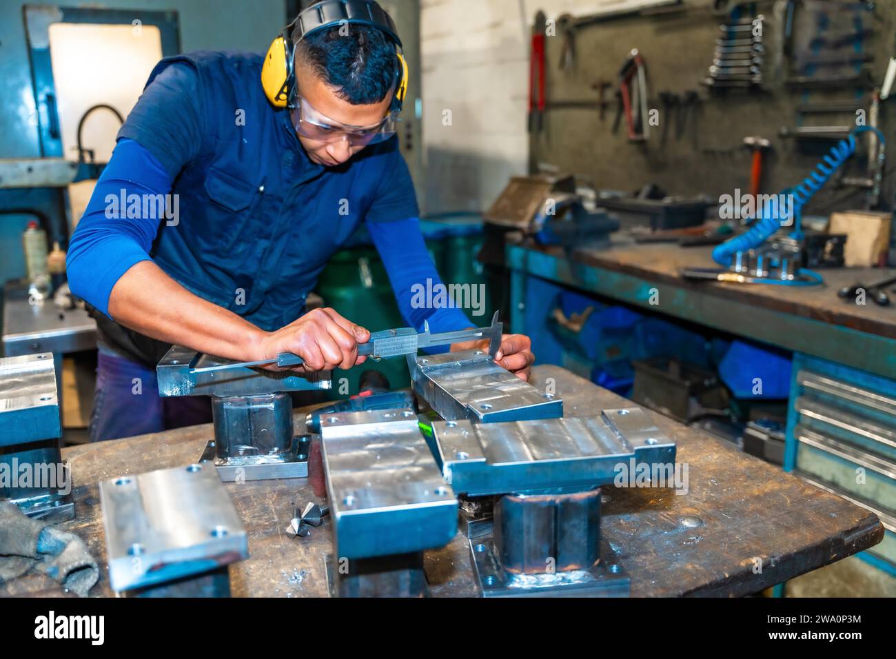 A Latin operator making measurements with the caliper on a milling ...