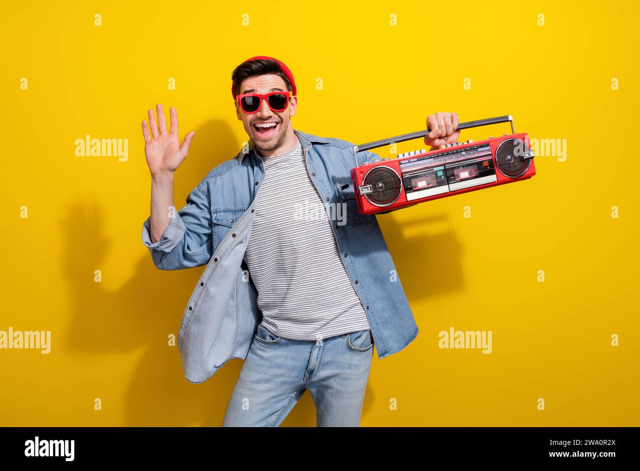 Photo of funky friendly man dressed jeans shirt dark spectacles waving ...